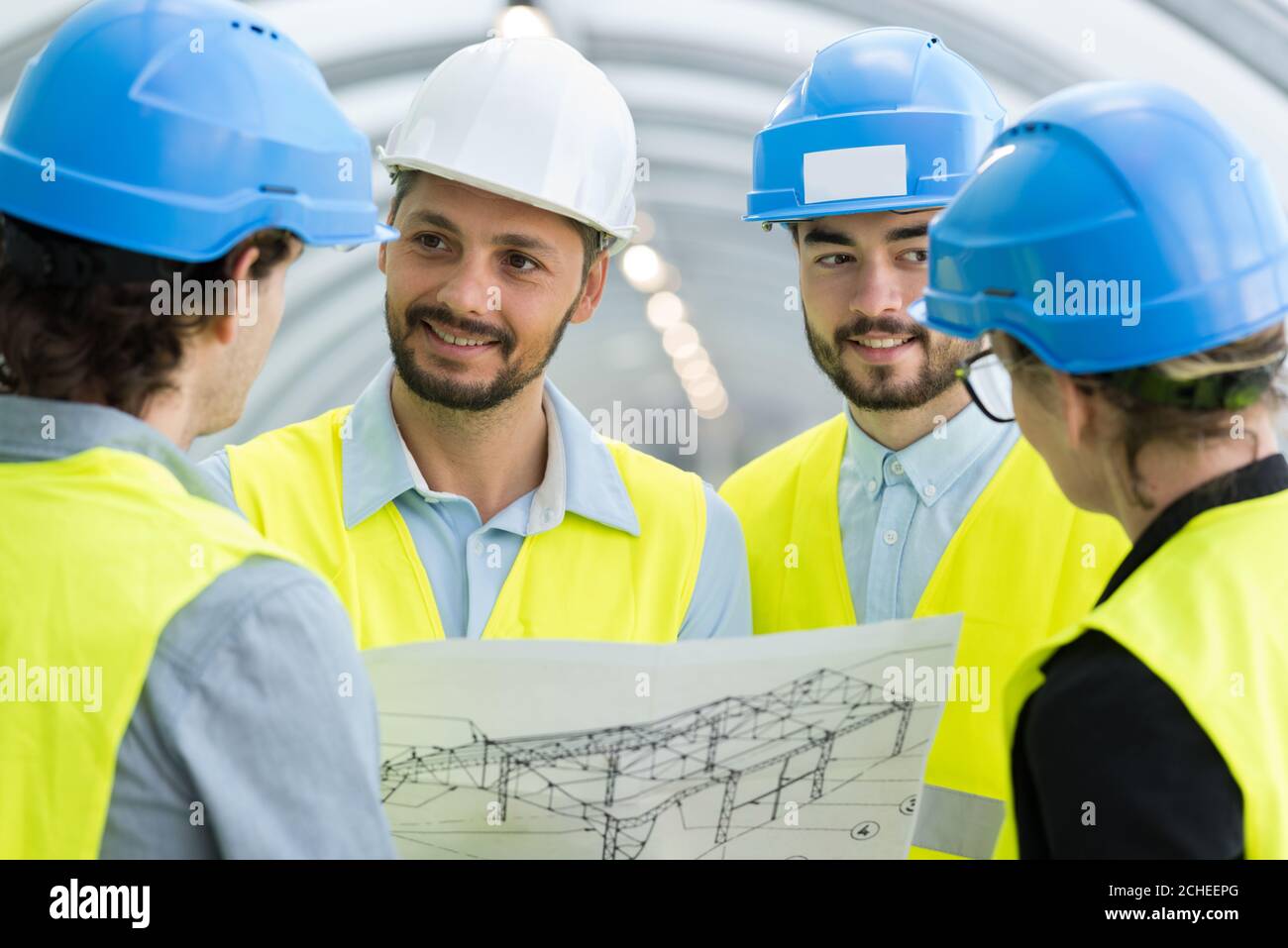 four engineer and safety staff working together in construction-site ...