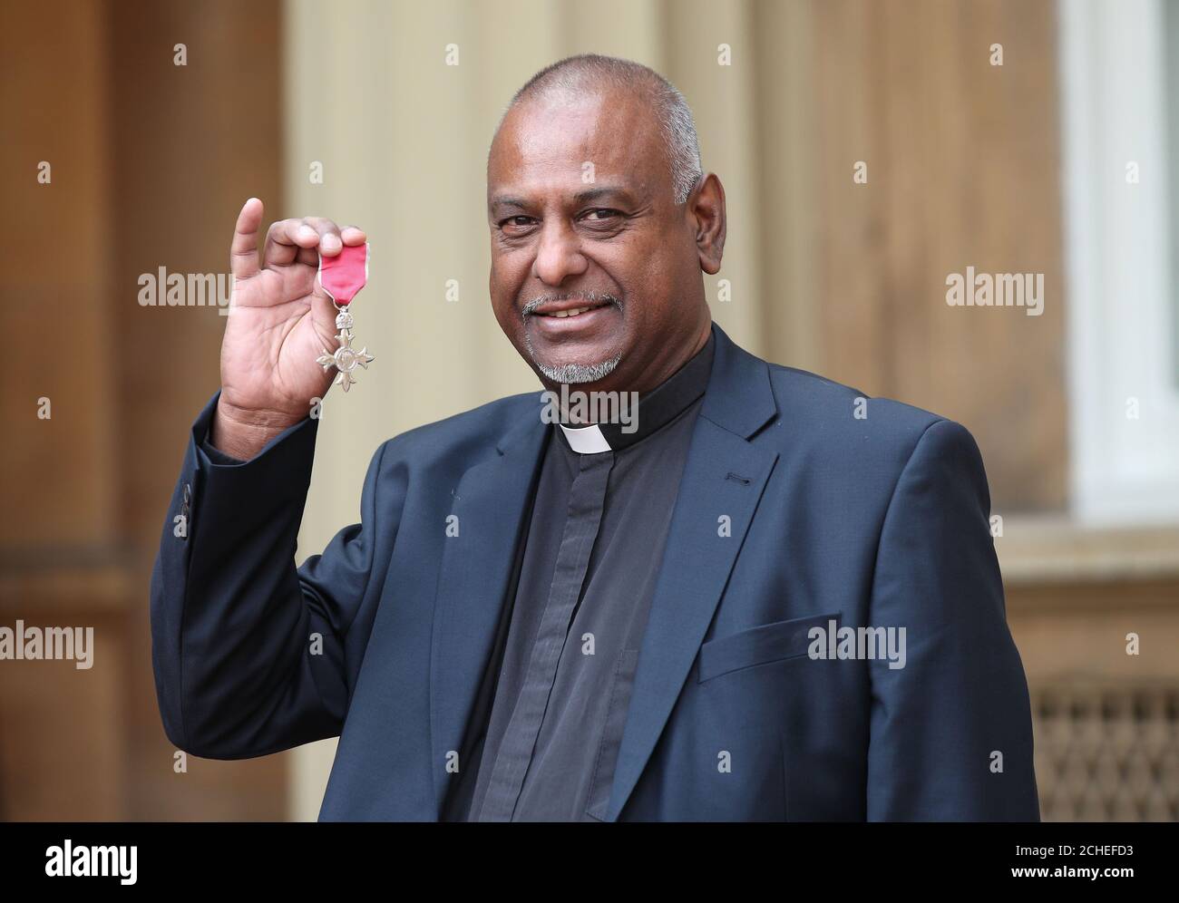 The Very Reverend Rogers Govender with his MBE following an investiture ...