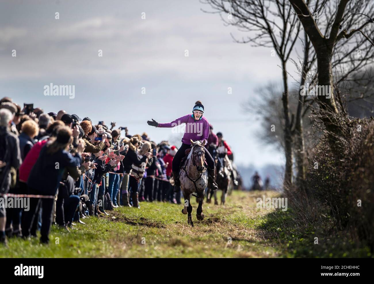 A riders cross the finish line during the Kiplingcotes Derby, England's ...