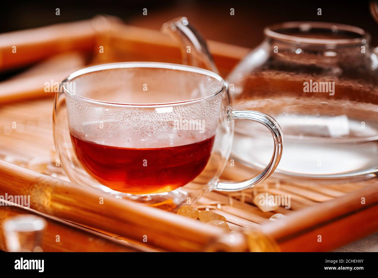 Cup of hot tea with rock sugar, dry tea leaves served in thermo glass ...
