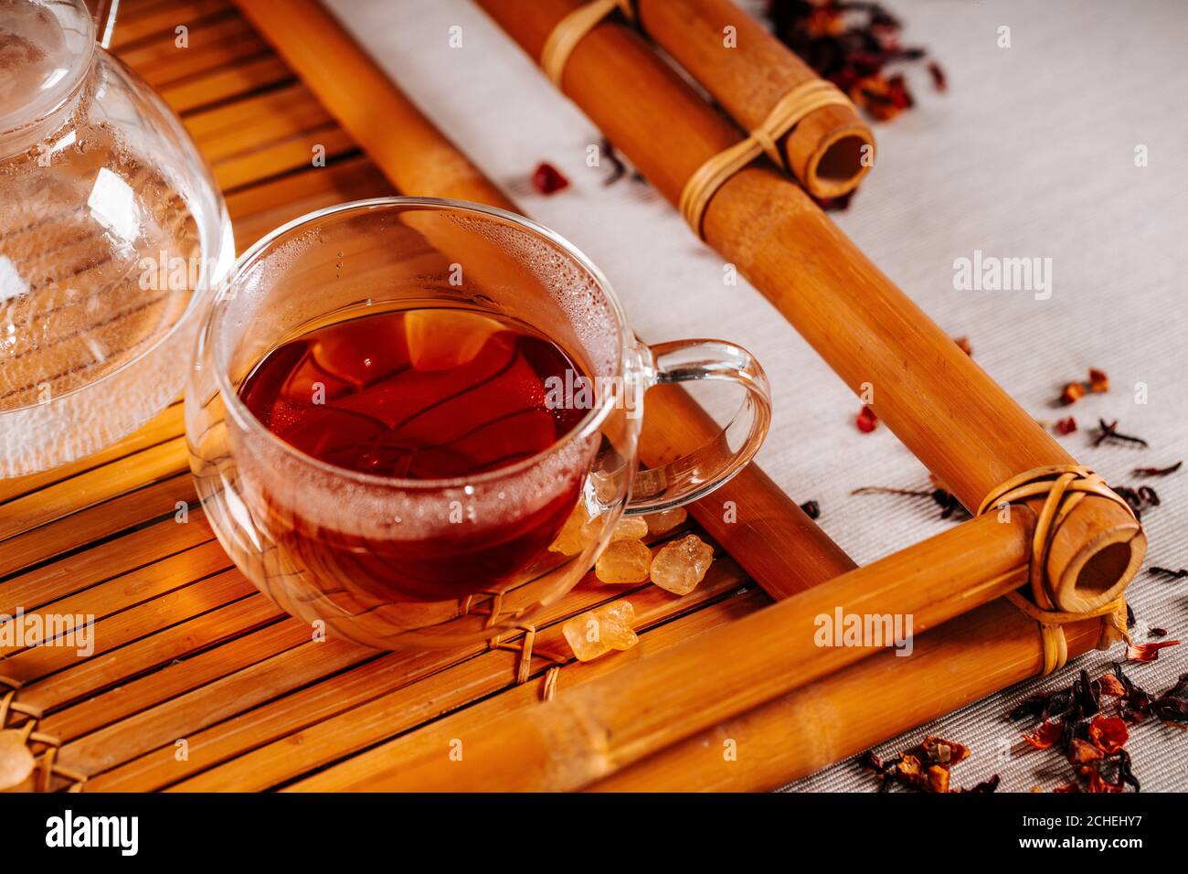 Cup of hot tea with rock sugar, dry tea leaves served in thermo glass ...