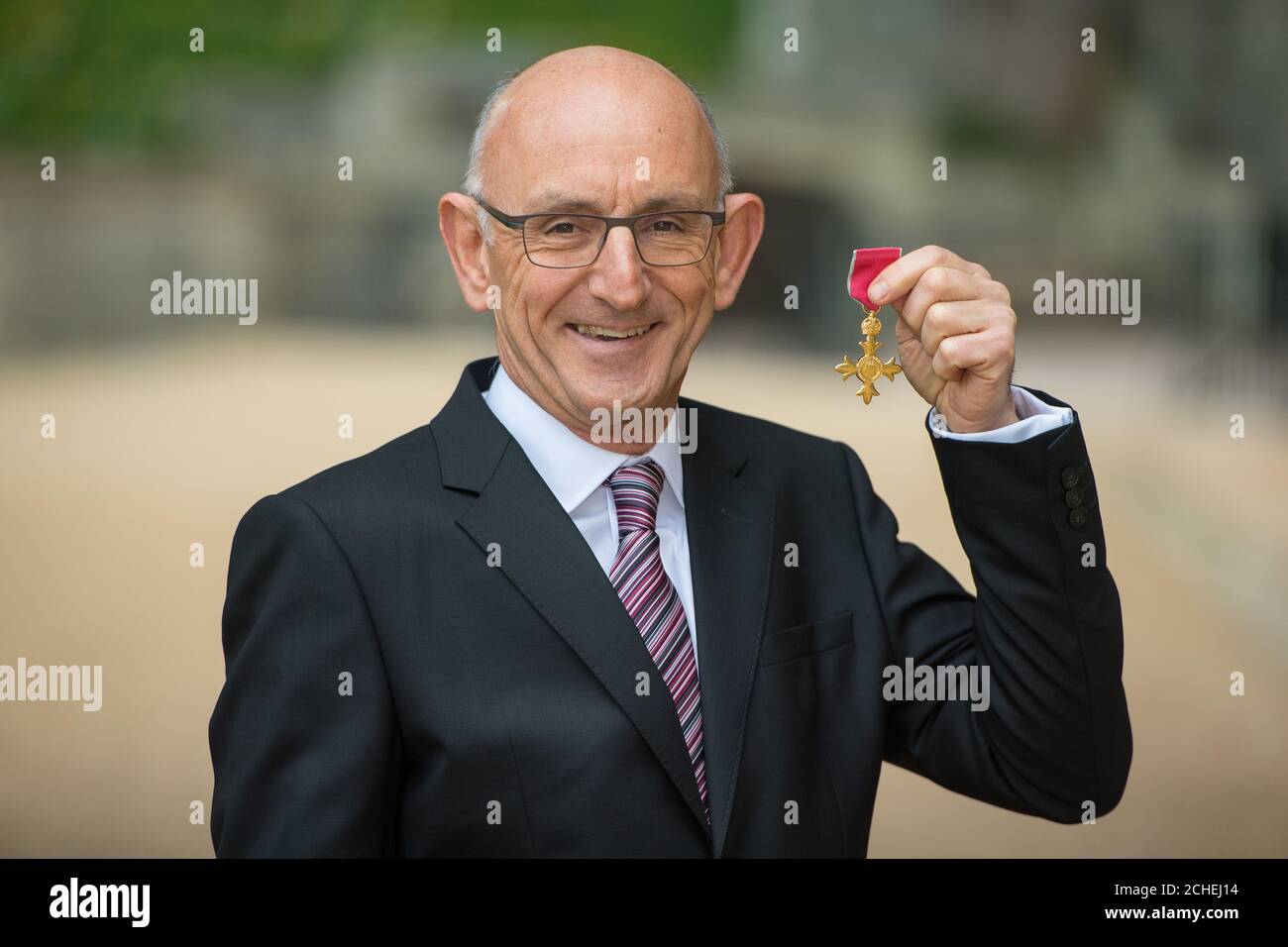 Roger Whiteside with his OBE medal, awarded by Queen Elizabeth II at an ...