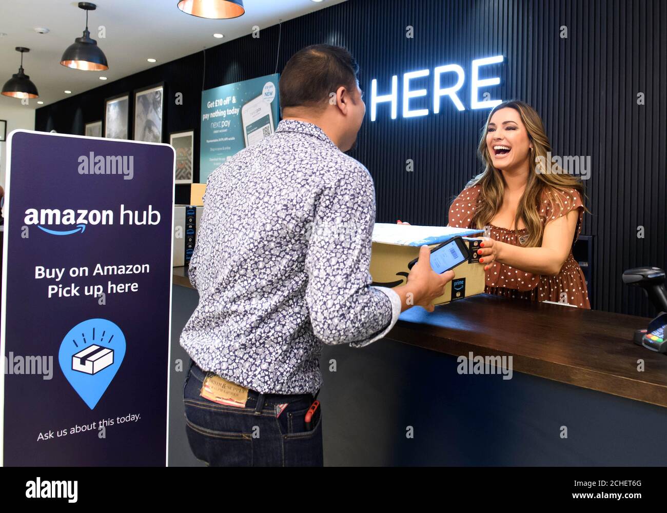 EDITORIAL USE ONLY Kelly Brook serves customers at NEXT???s flagship ...