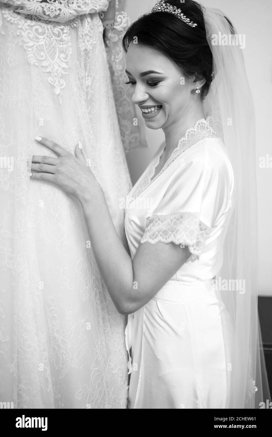 Pretty bride dressing up before wedding Stock Photo - Alamy