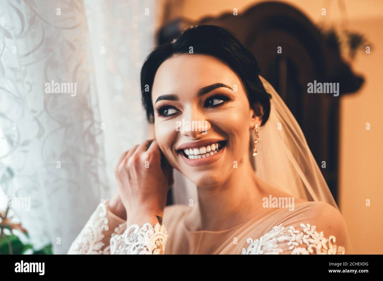 Pretty bride dressing up before wedding Stock Photo - Alamy