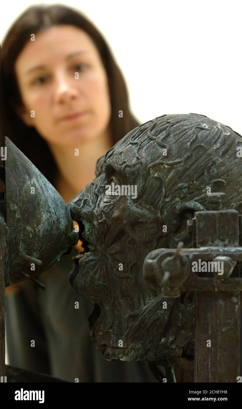 Exhibition curator Clarrie Wallis looks at a detail from 'When Humans ...
