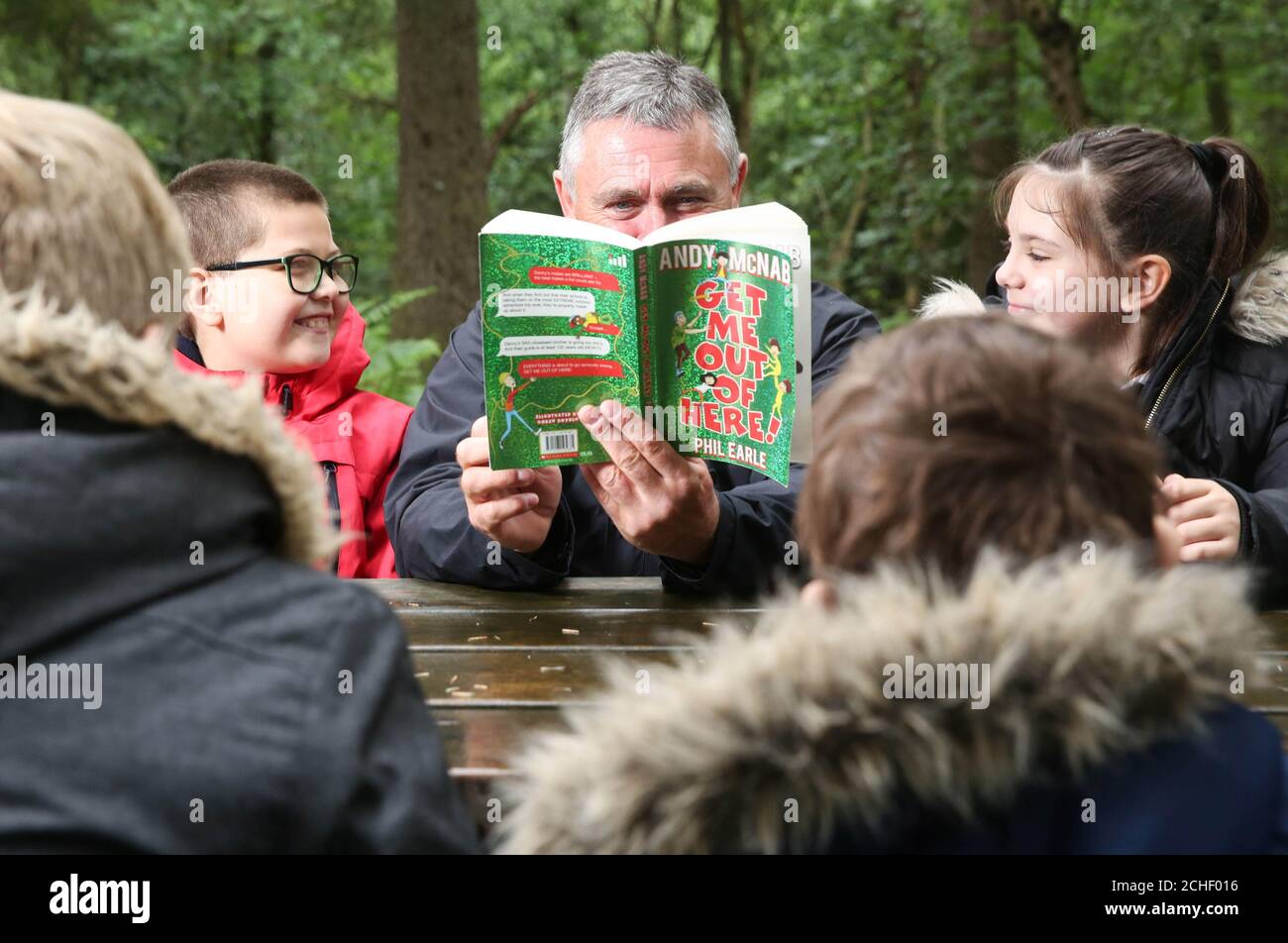 EDITORIAL USE ONLY Former SAS soldier Andy McNab reads to Sam Gould ...