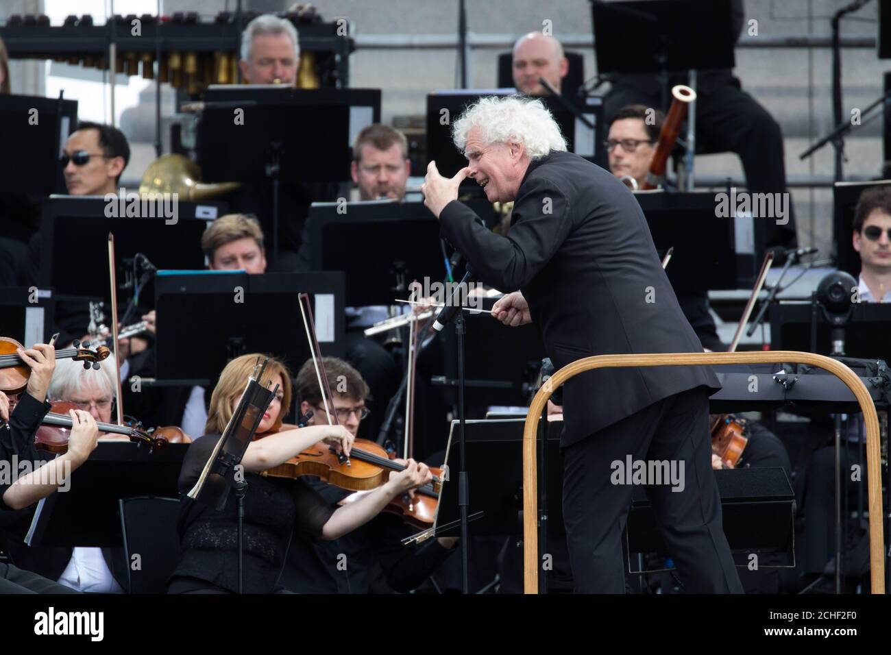 Sir Simon Rattle conducts the London Symphony Orchestra with musicians ...