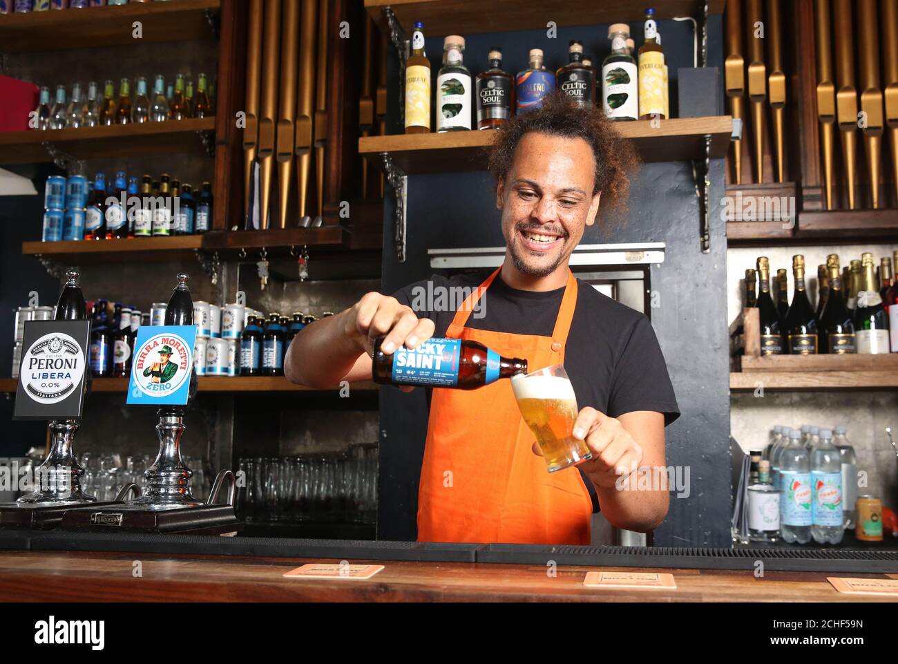 EDITORIAL USE ONLY Bartender Kieran Jay Johnson serves drinks to ...