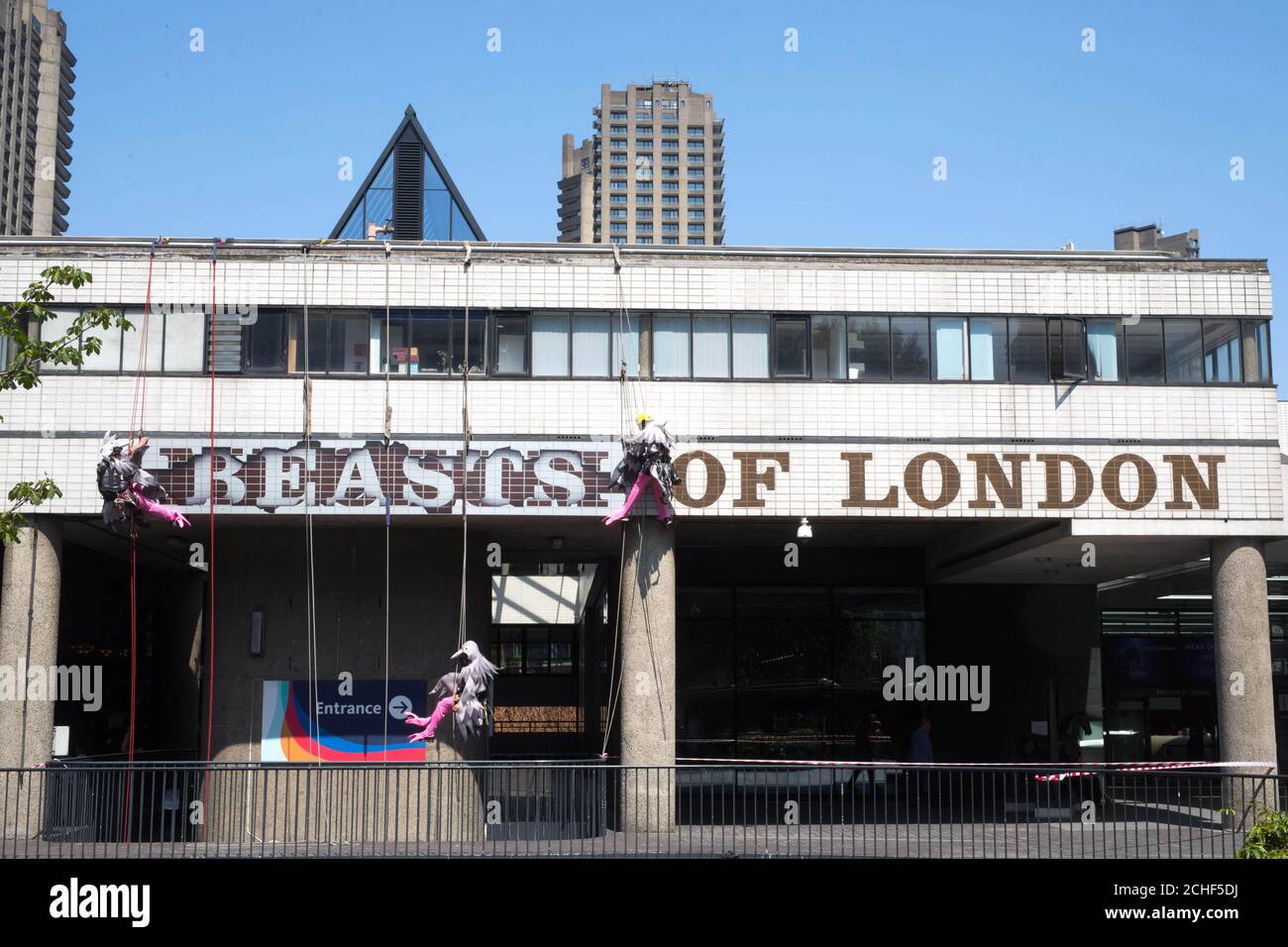 EDITORIAL USE ONLY Rope access workers dressed as pigeons abseil down ...