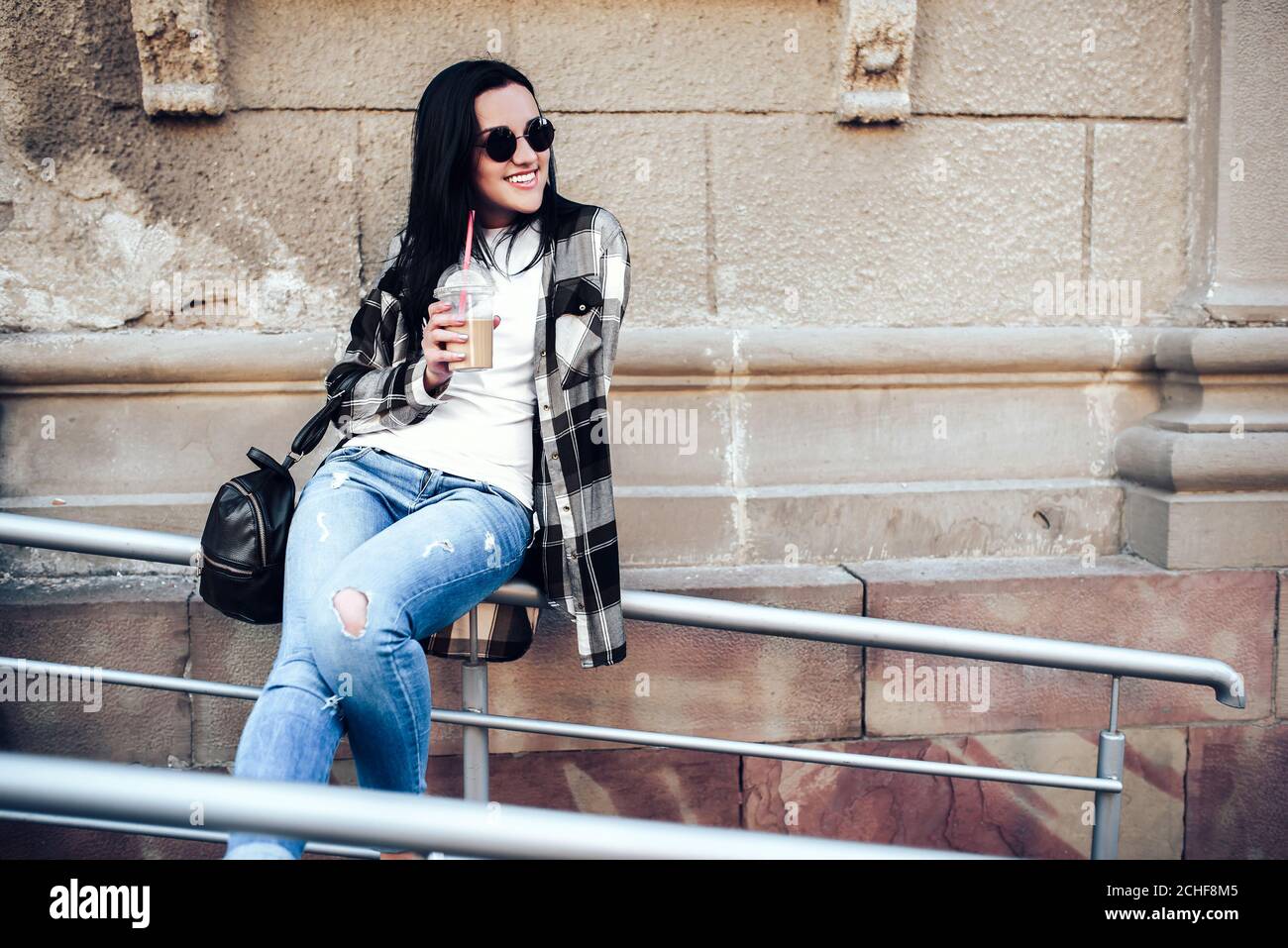 Pretty brunette girl drinking cold coffee outdoor Stock Photo - Alamy