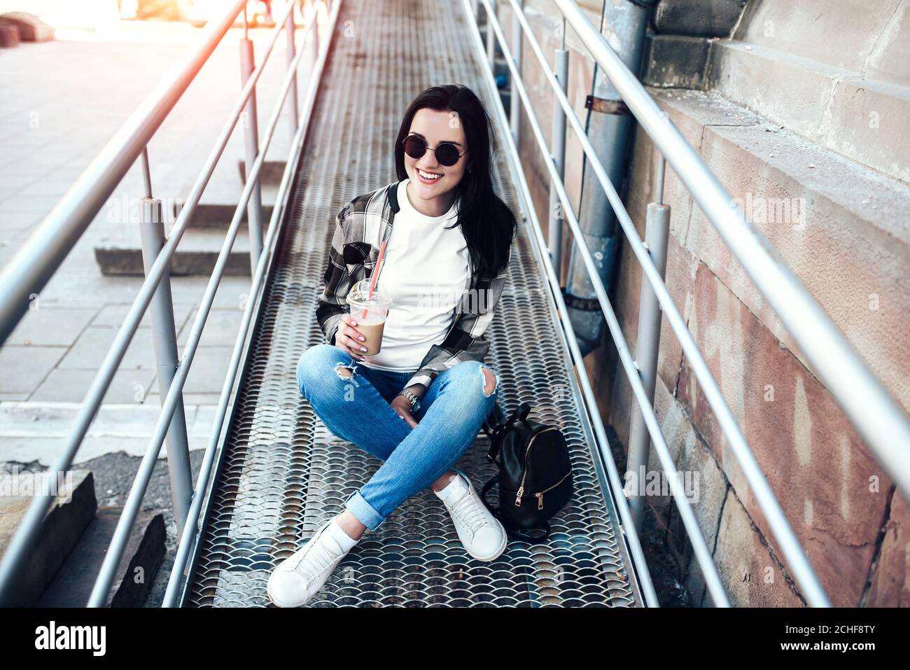 Pretty brunette girl drinking cold coffee outdoor Stock Photo - Alamy