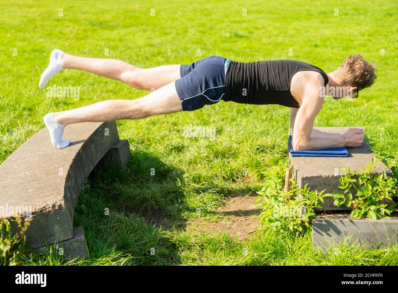 Young man performing single leg plank exercise in an outdoors ...
