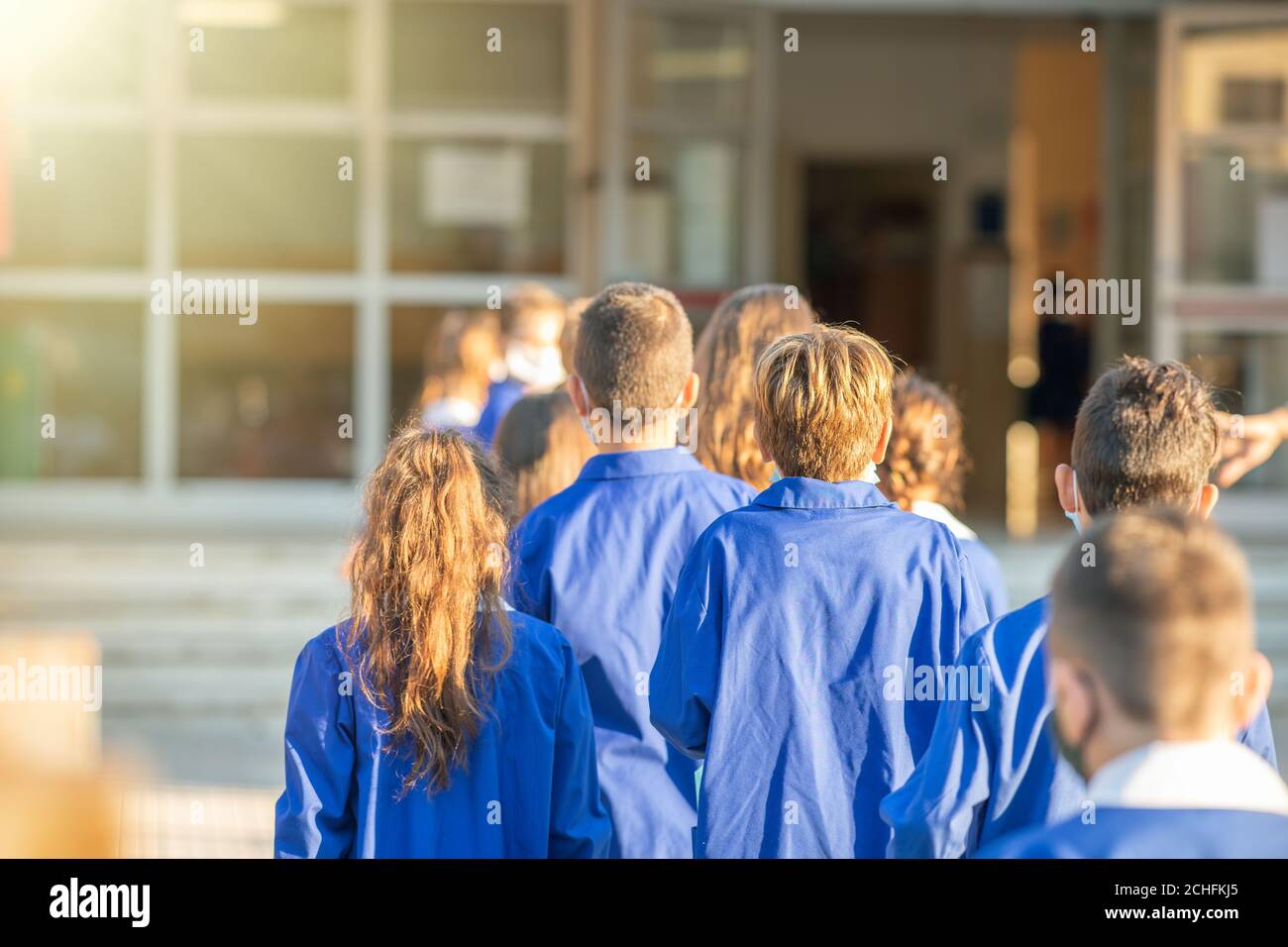 Back view of primary school classmates on the first day of lessons ...