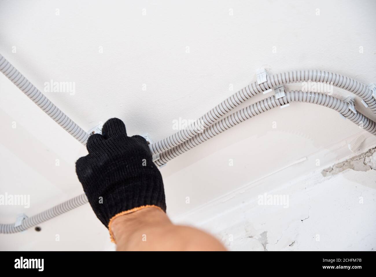 Electrician fixing electric cable to the wall, close up Stock Photo - Alamy