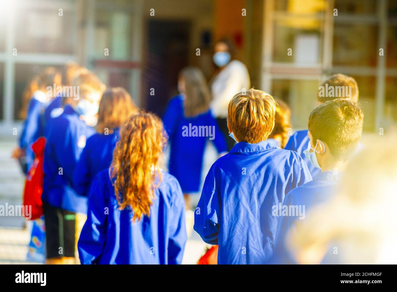 Back view of primary school classmates on the first day of lessons ...