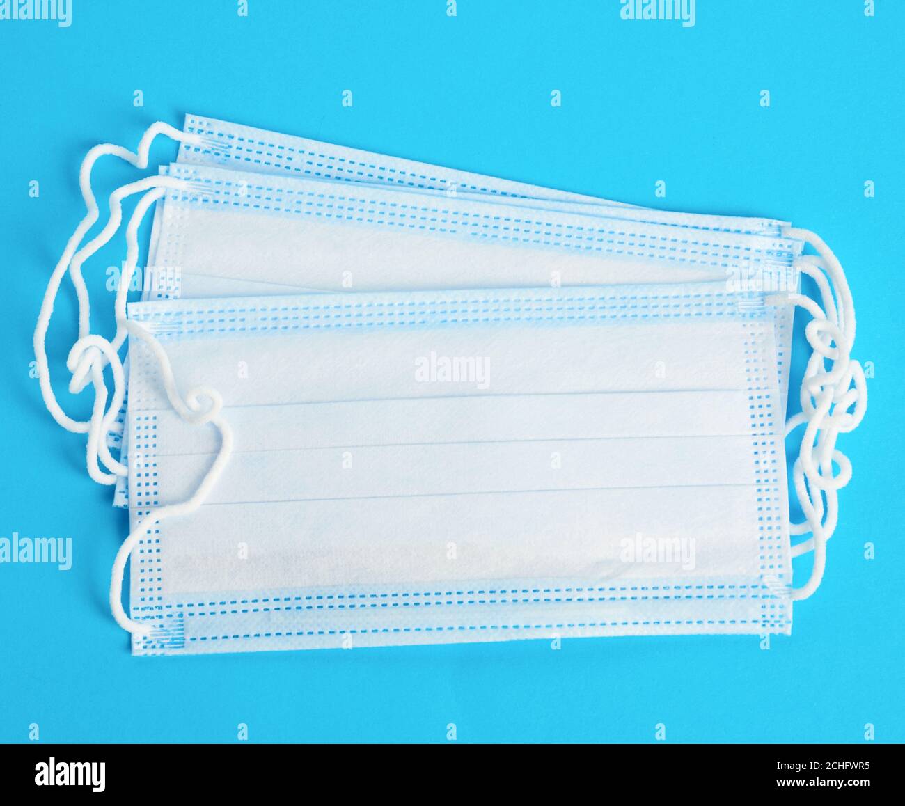 blue disposable medical mask on a blue background, personal protective ...