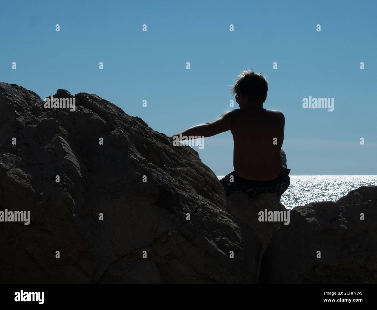 Boy sitting back view hi-res stock photography and images - Alamy