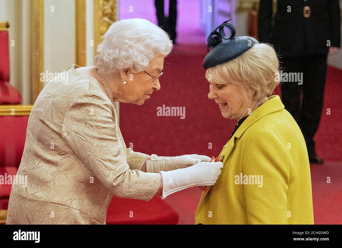 Queen Elizabeth II wears gloves as she awards the CBE (Commander of the ...