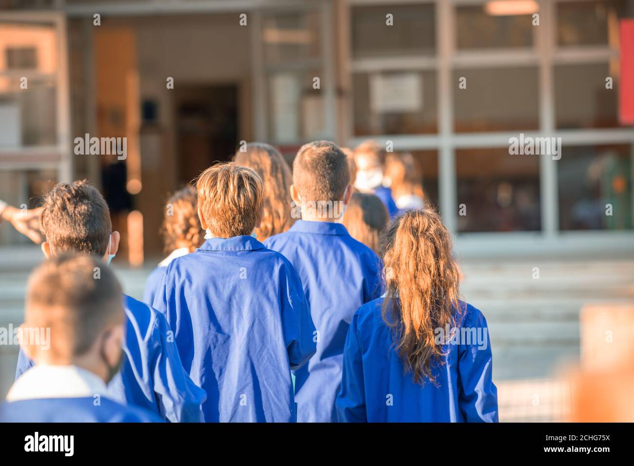 Back view of primary school classmates on the first day of lessons ...