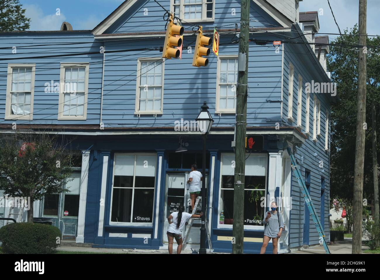 Blue House at Traffic Intersection with Painters Painting the House as ...