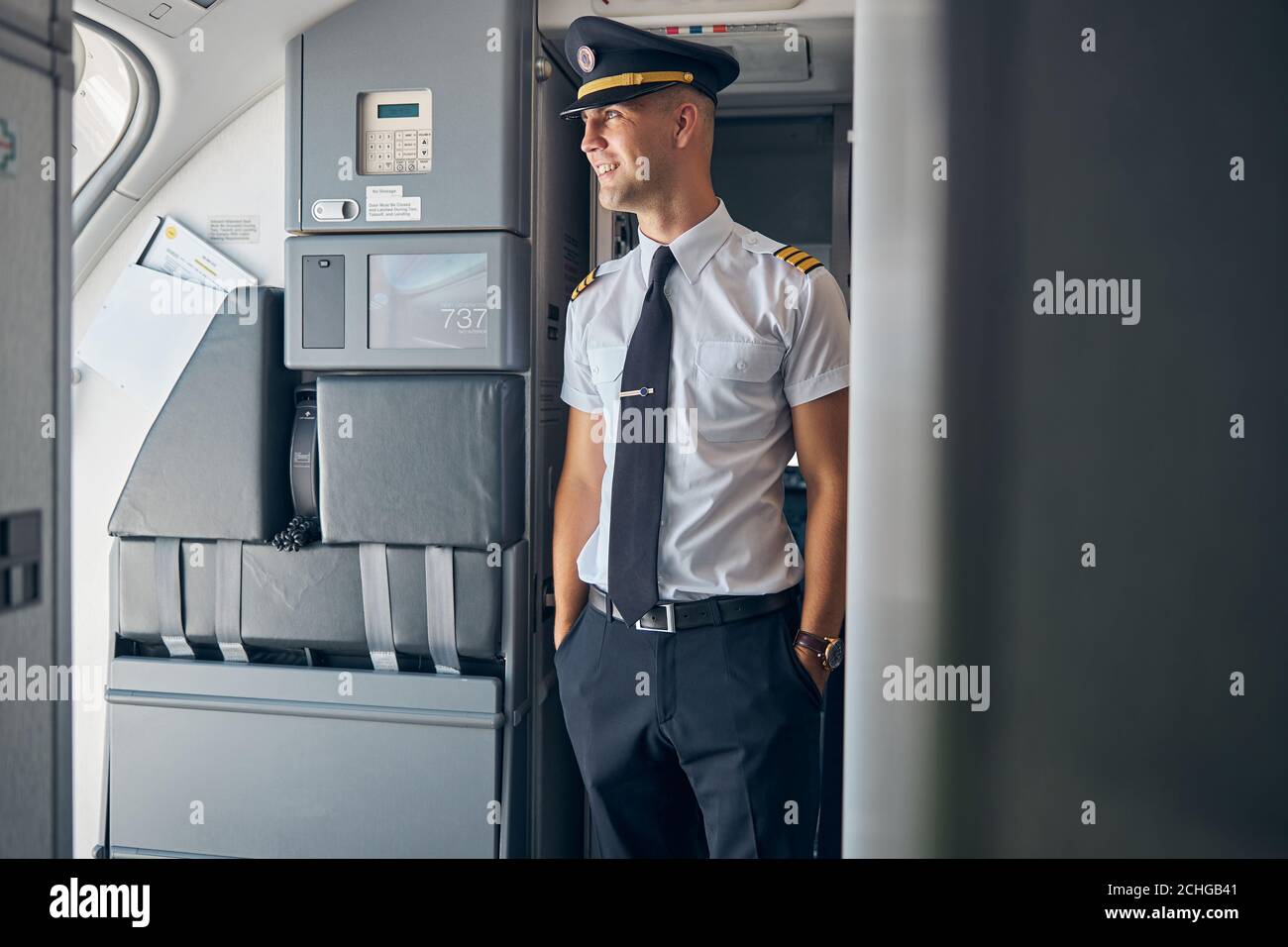 Handsome male captain standing inside commercial airplane Stock Photo ...