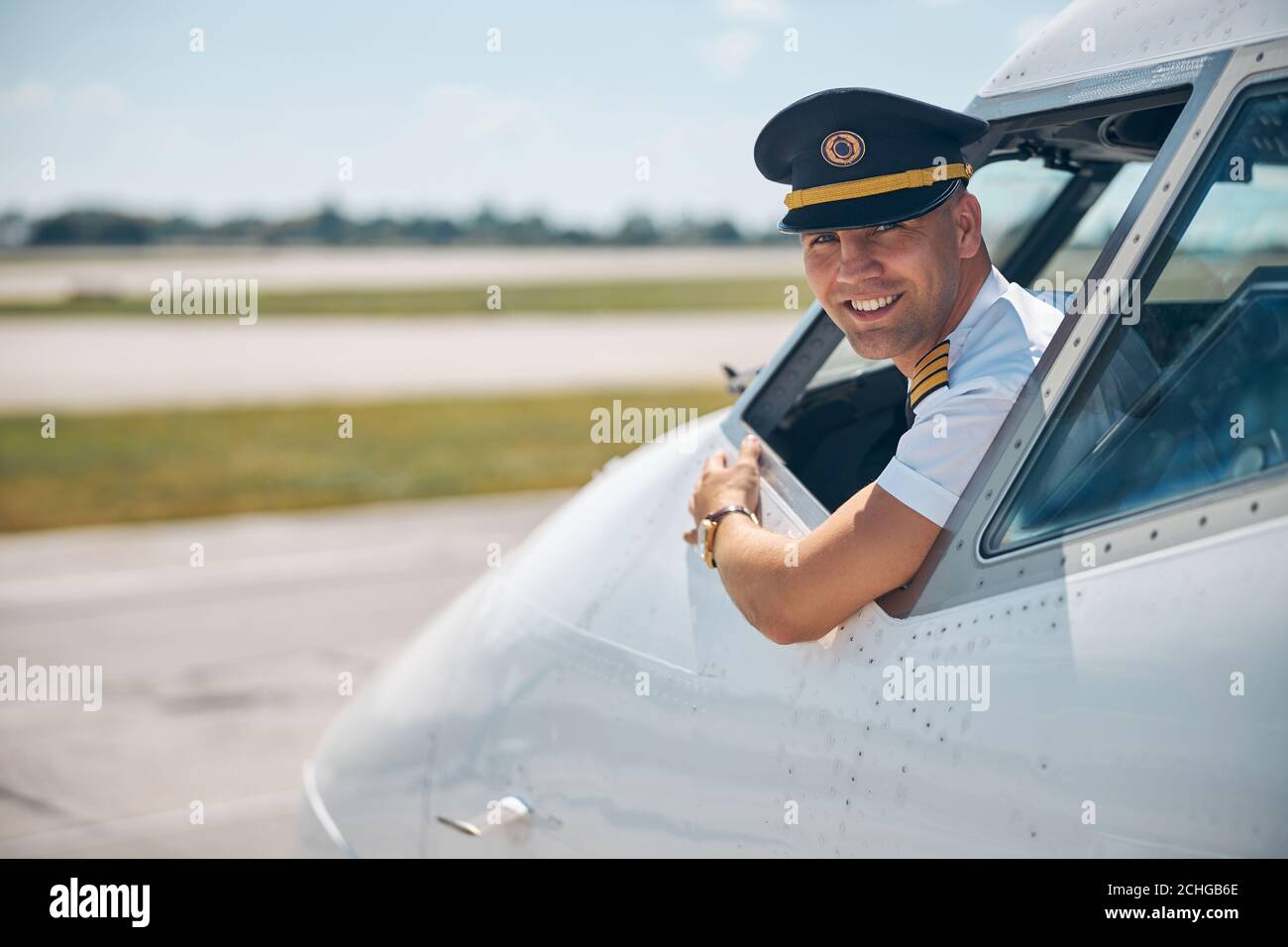 Cheerful young pilot sitting inside plane cockpit Stock Photo - Alamy