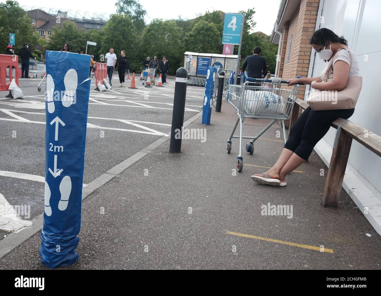 People practice social distancing while queuing outside a Tesco Extra ...