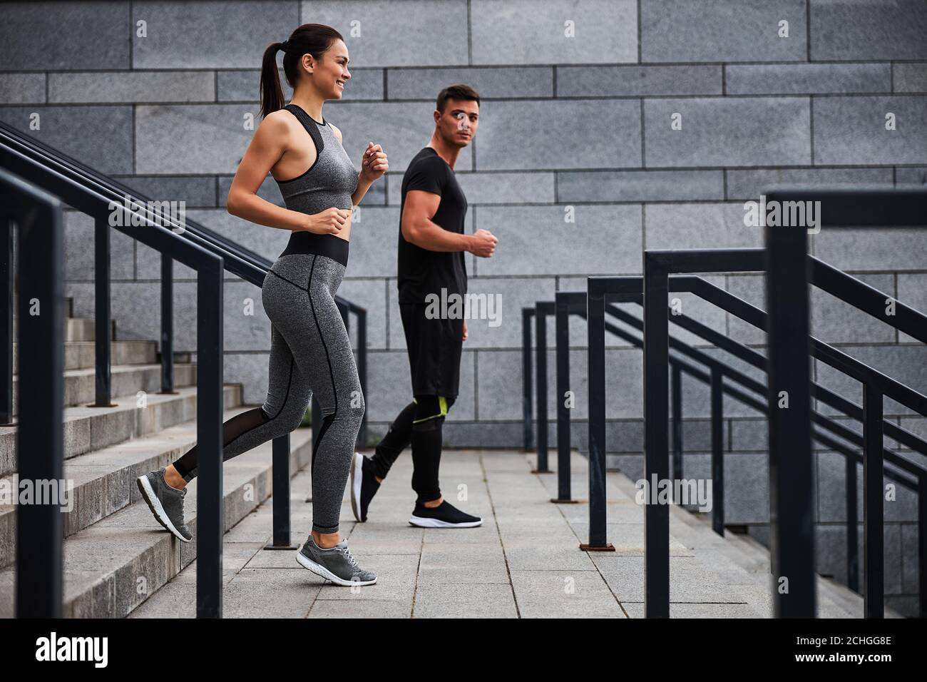 Merry woman running with boyfriend in city Stock Photo - Alamy