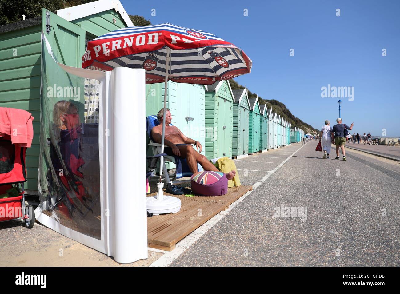 Rob Underhill (right) and his wife Sally sit outside their beach hut as ...