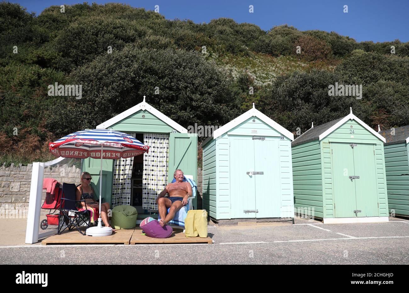 Rob Underhill (right) and his wife Sally sit outside their beach hut as ...