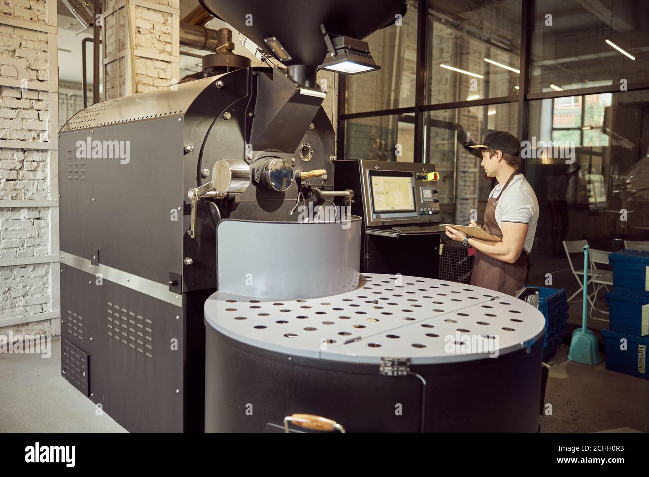 Male worker using control panel of coffee roasting machine Stock Photo ...