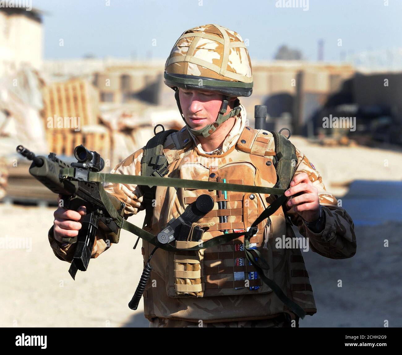 Prince Harry holds his SA80 rifle as he patrols the deserted town of ...
