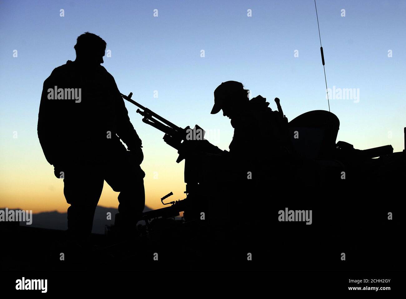 Prince Harry (right) checks the machine gun on his spartan armoured ...