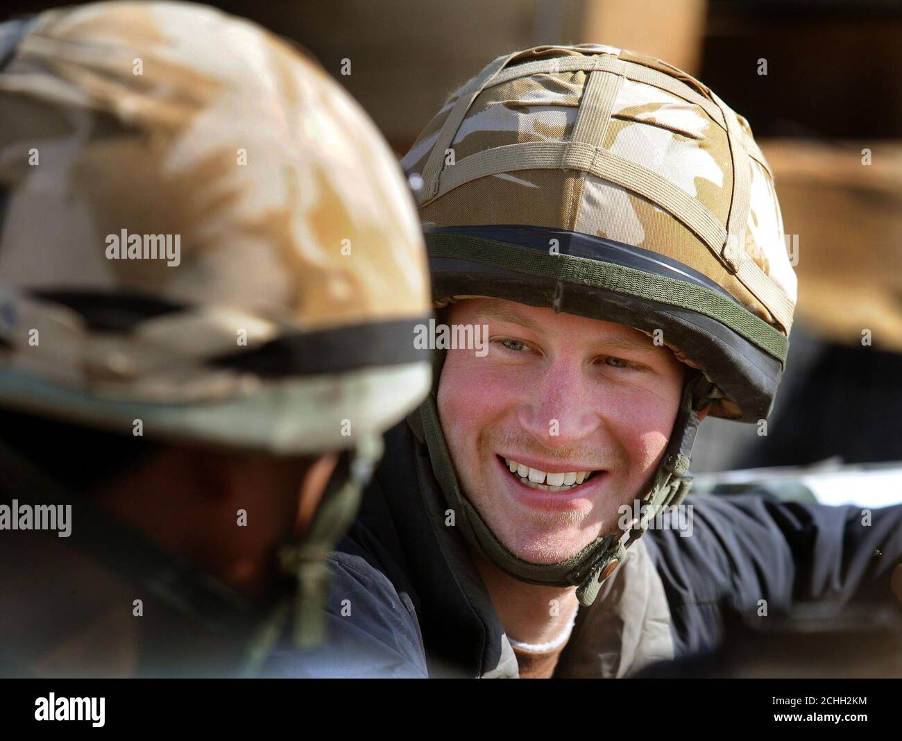 Prince Harry chats to a Gurkha soldier after firing a 50mm machine gun ...