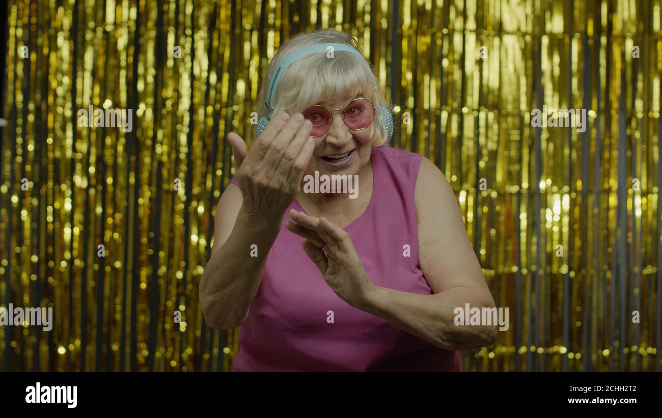 Friendly positive senior old blond woman waving hands looking at camera ...