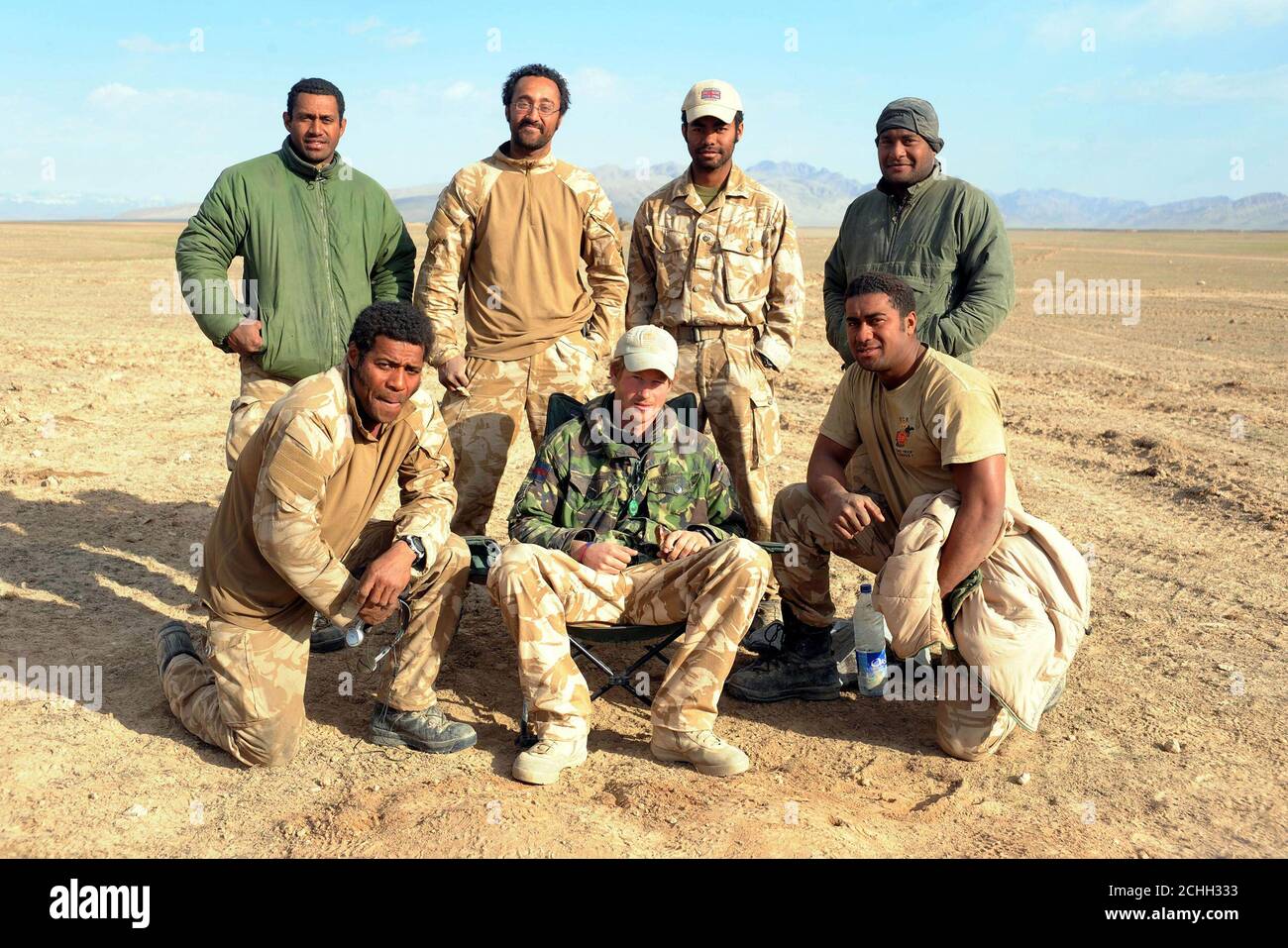 Prince Harry poses with a group of Fijian soldiers in the desert in ...