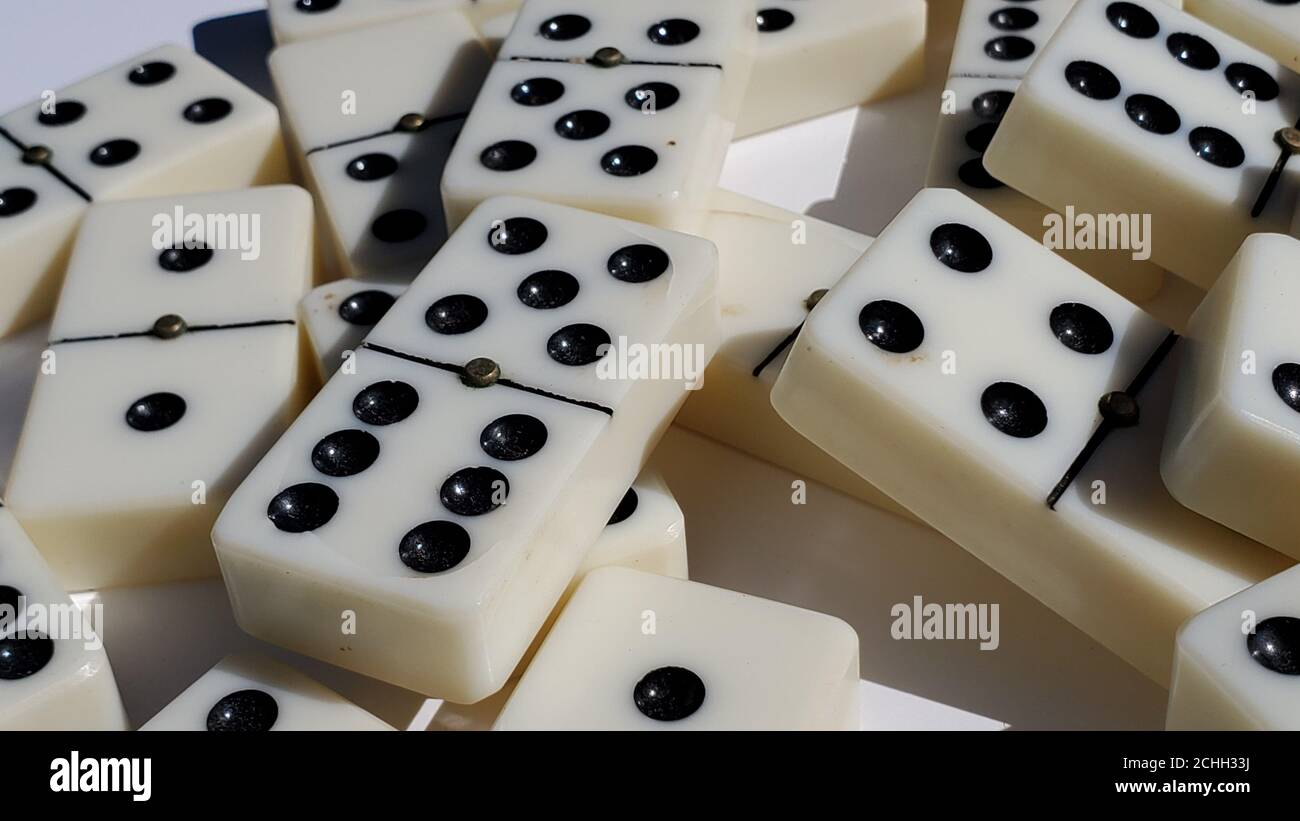 Ivory dominoes in a pile with a white background Stock Photo - Alamy