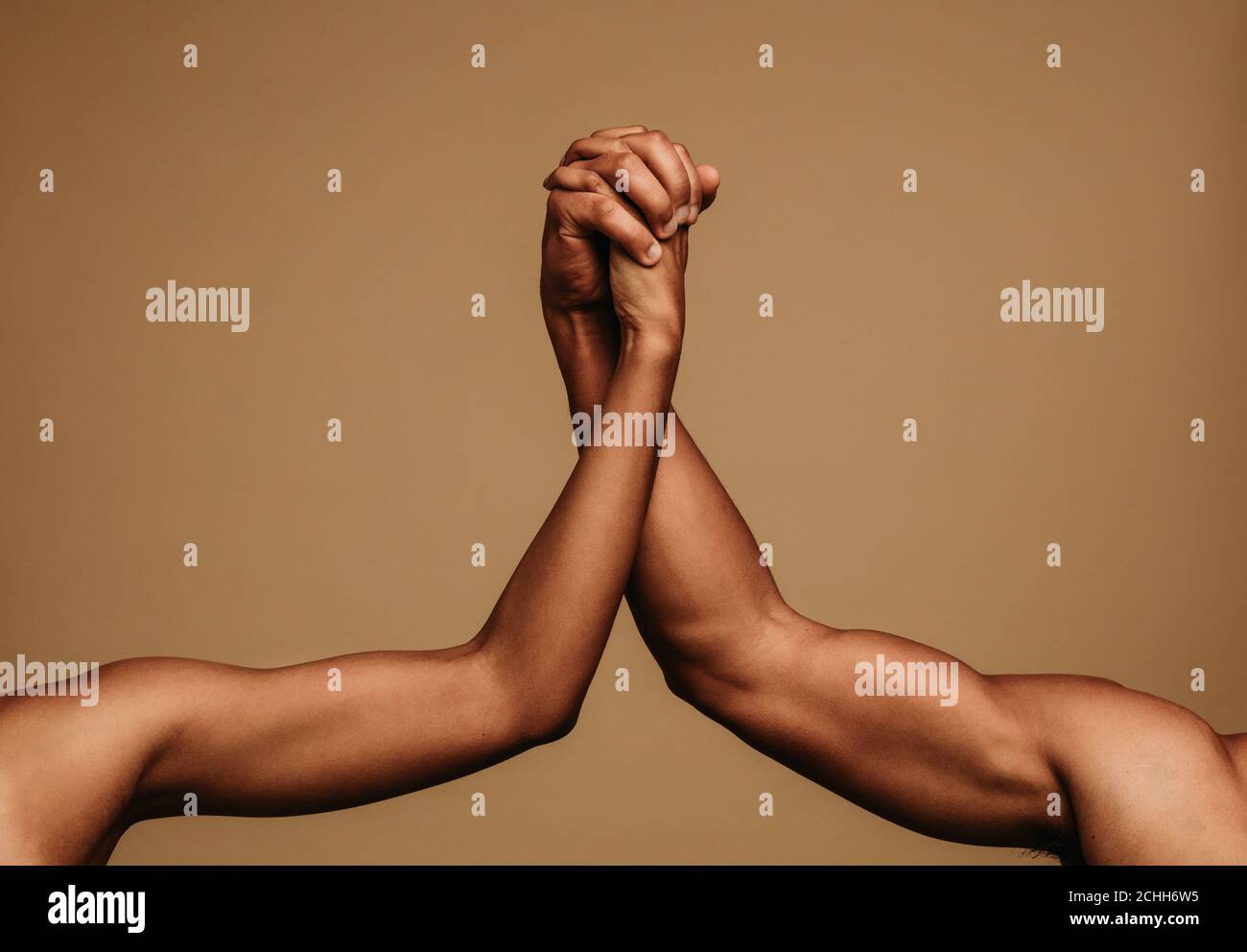 Cropped shot of two arms holding each other symbolising unity. Male and ...