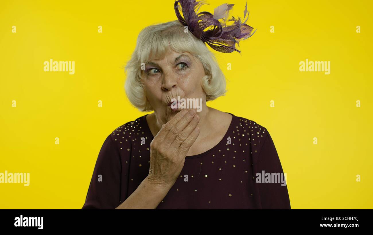 Shocked frightened senior old woman covering mouth with hand and ...