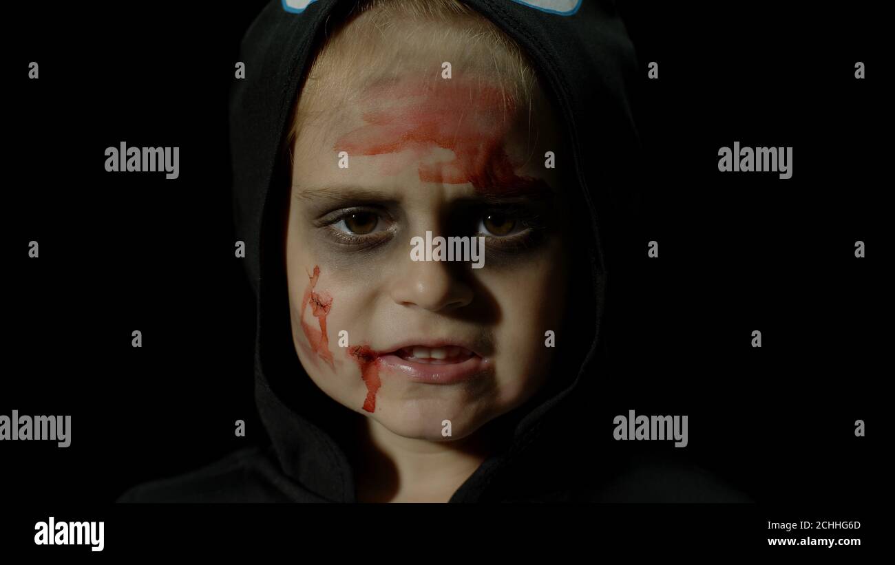 Halloween, angry child girl with blood makeup on her face. Kid dressed ...