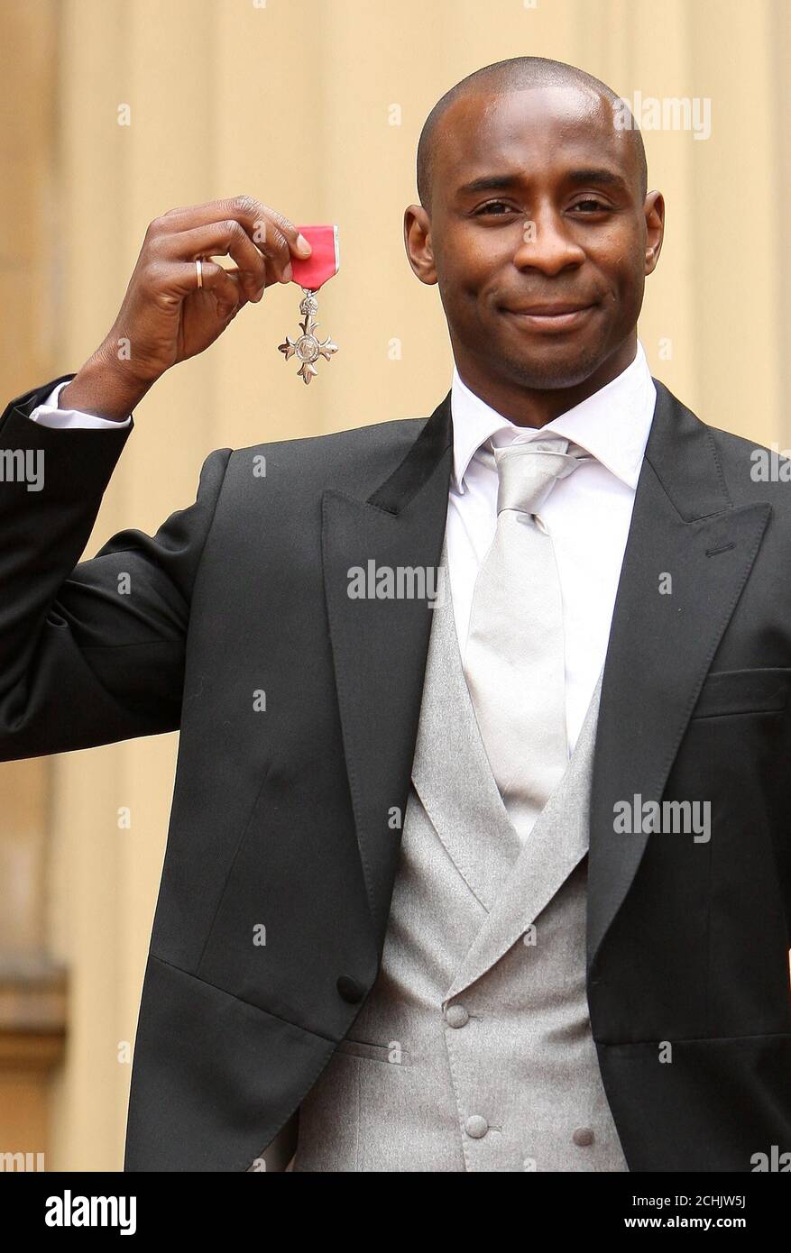 Blackburn Rovers footballer Jason Roberts holds up his MBE, which was ...