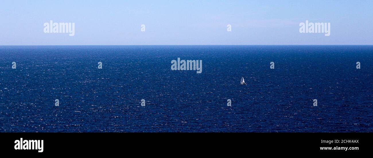 Distant sailboat on open sea Stock Photo - Alamy