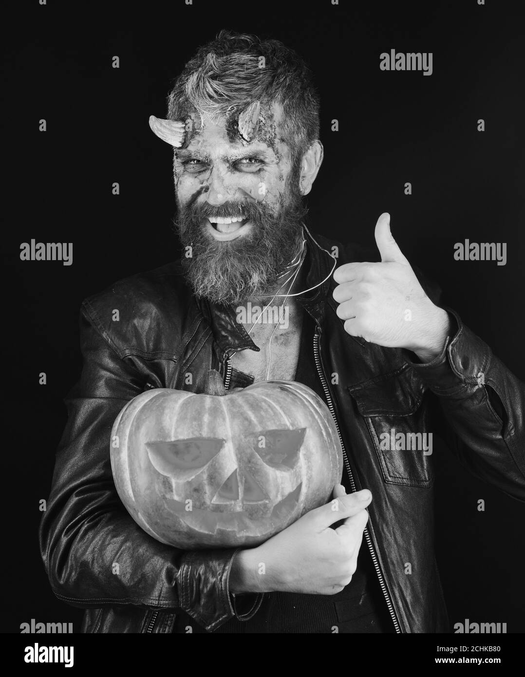 Devil or monster with October decorations. Man wearing scary makeup ...