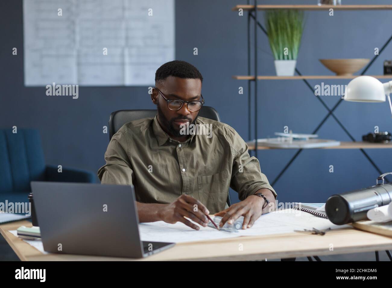 Afro-American architect working in office with blueprints.Engineer ...