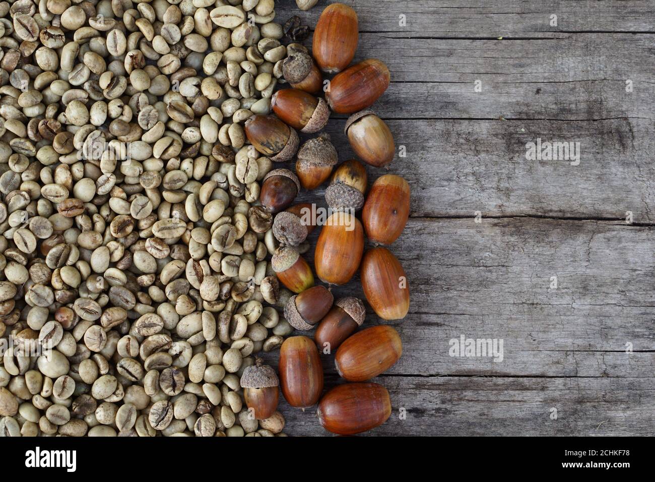 Flat lay of middle roasted coffee beans and acorn on wooden background ...