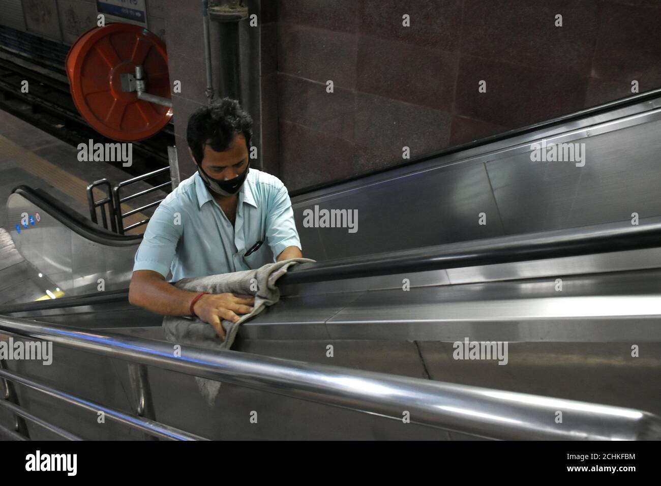 A Metro rail Worker sanitize the escalator handle in a metro station ...