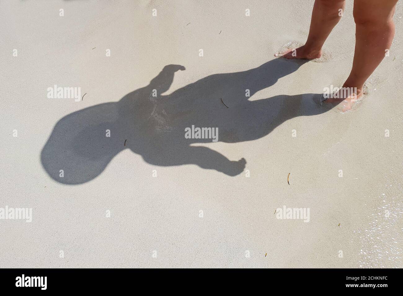 Low angle shot of a person's shadow on the beach sand Stock Photo - Alamy