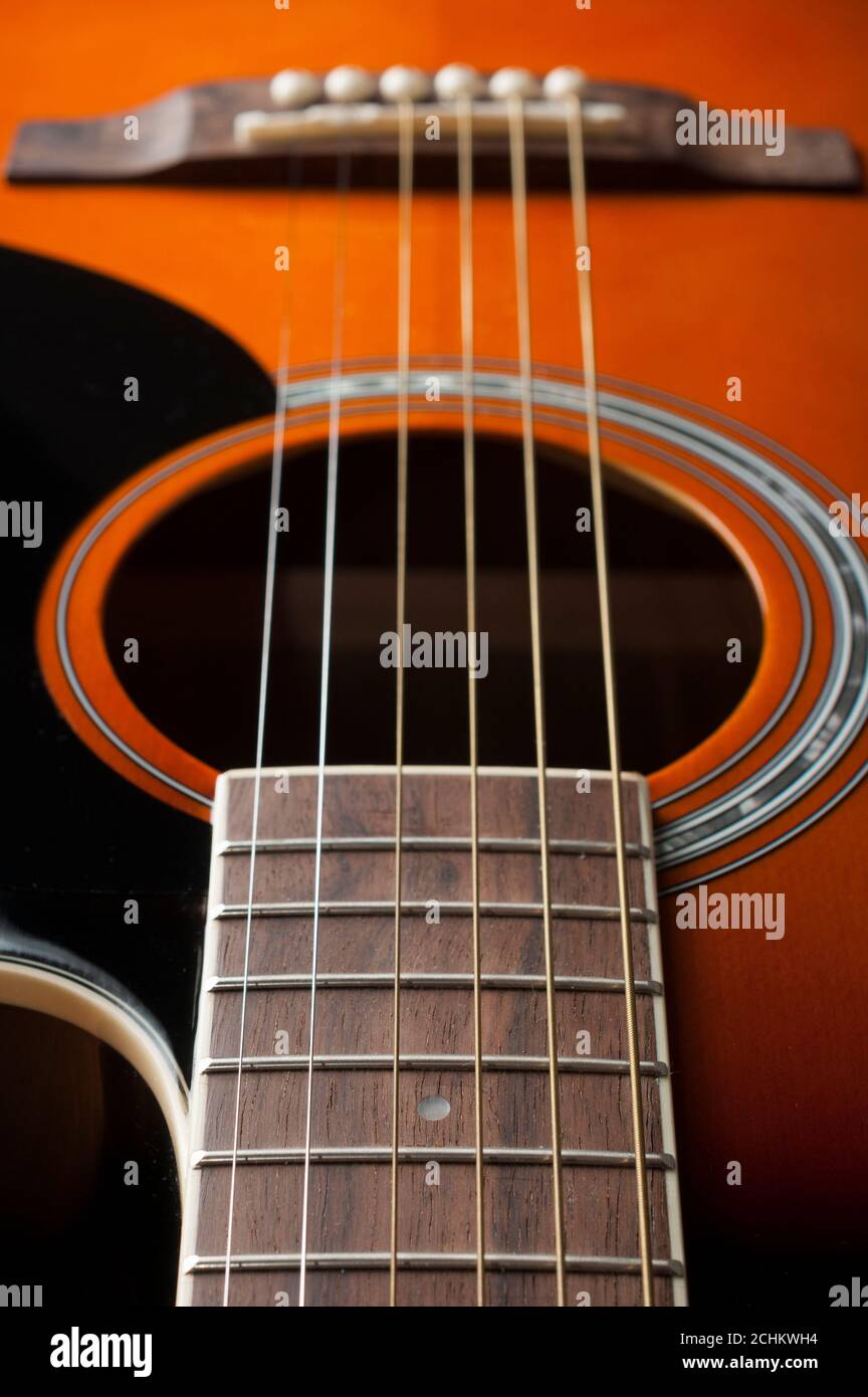 Detail of the fretboard and body of an acoustic guitar, shallow depth ...