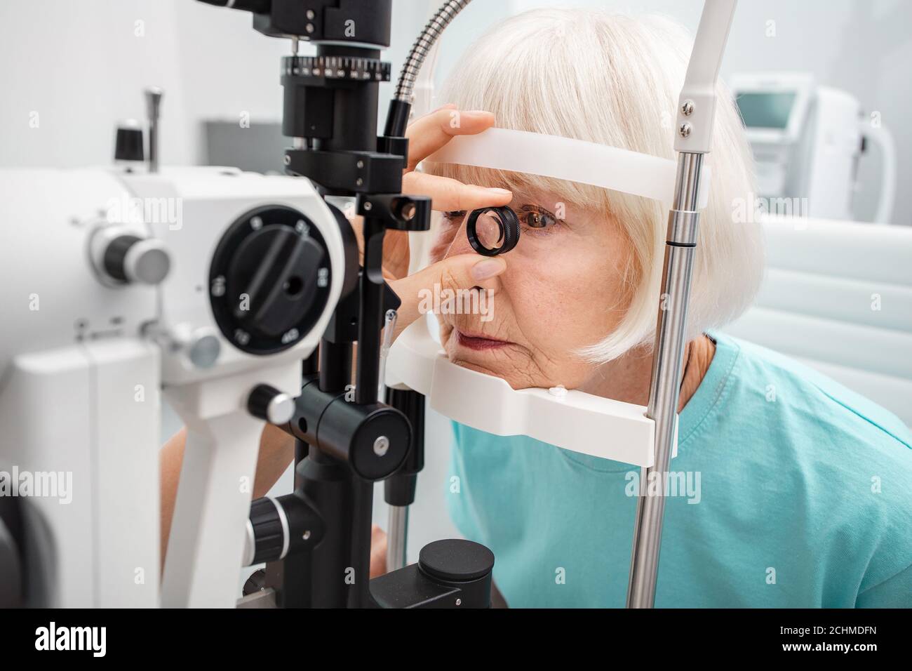 Senior woman eyesight test with binocular slit-lamp. Checking retina of ...